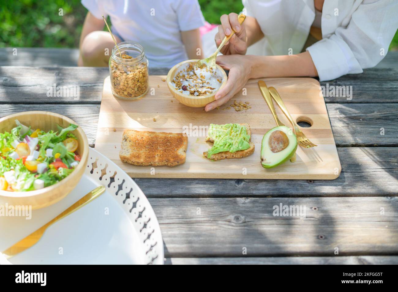 Crop woman and kid eating healthy breakfast breakfast in park Stock ...