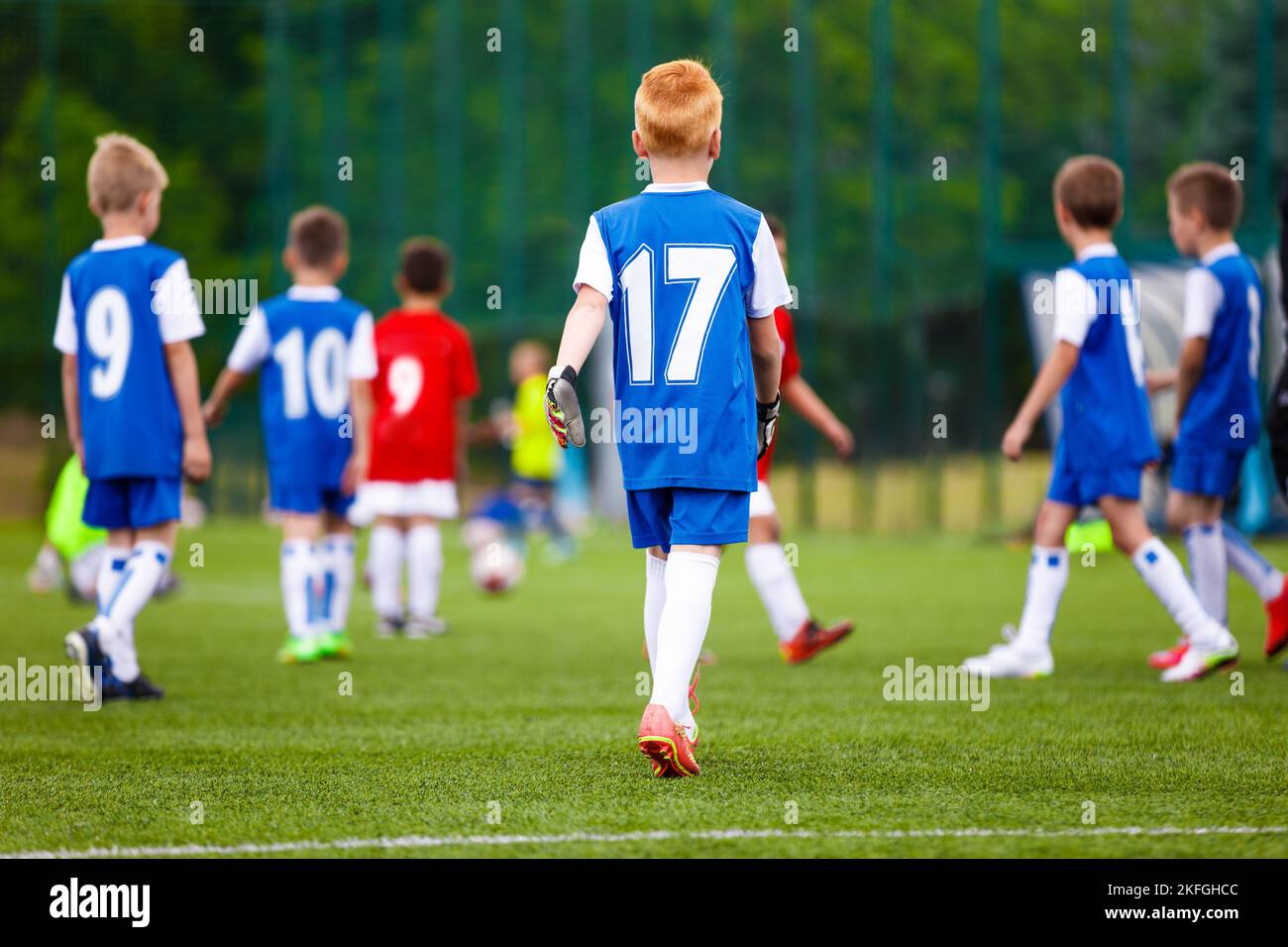 Young redhead soccer boy play football tournament game. Kids in blue ...