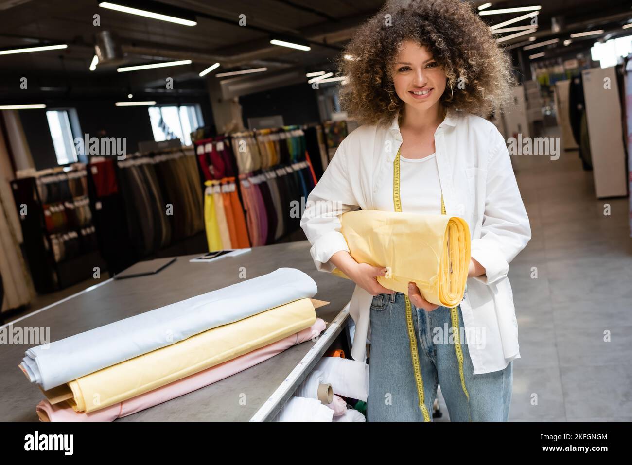 Woman holding roll of fabric in textile shop hi-res stock photography ...