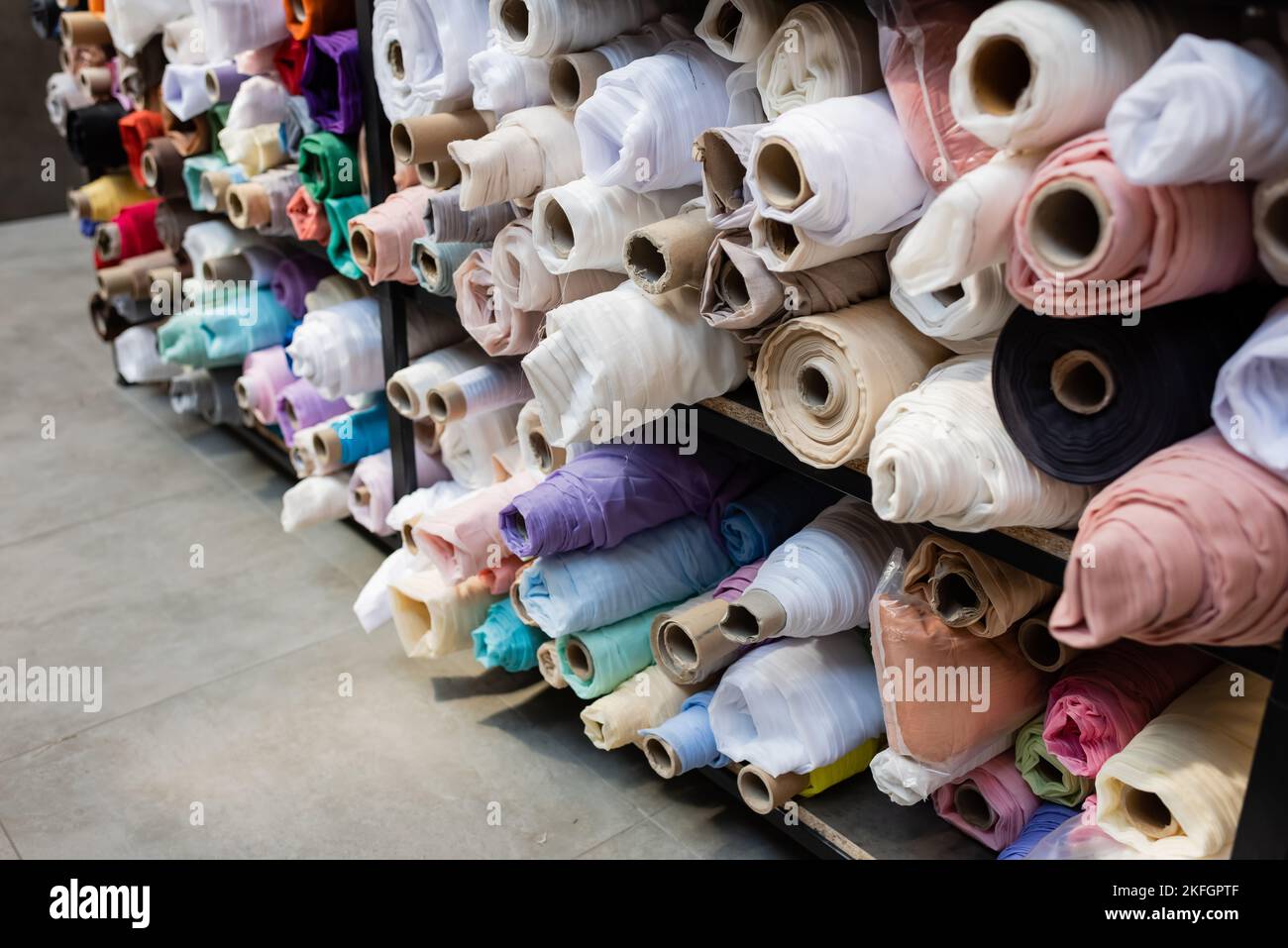 Colorful fabric rolls on shelves in textile shop Stock Photo - Alamy