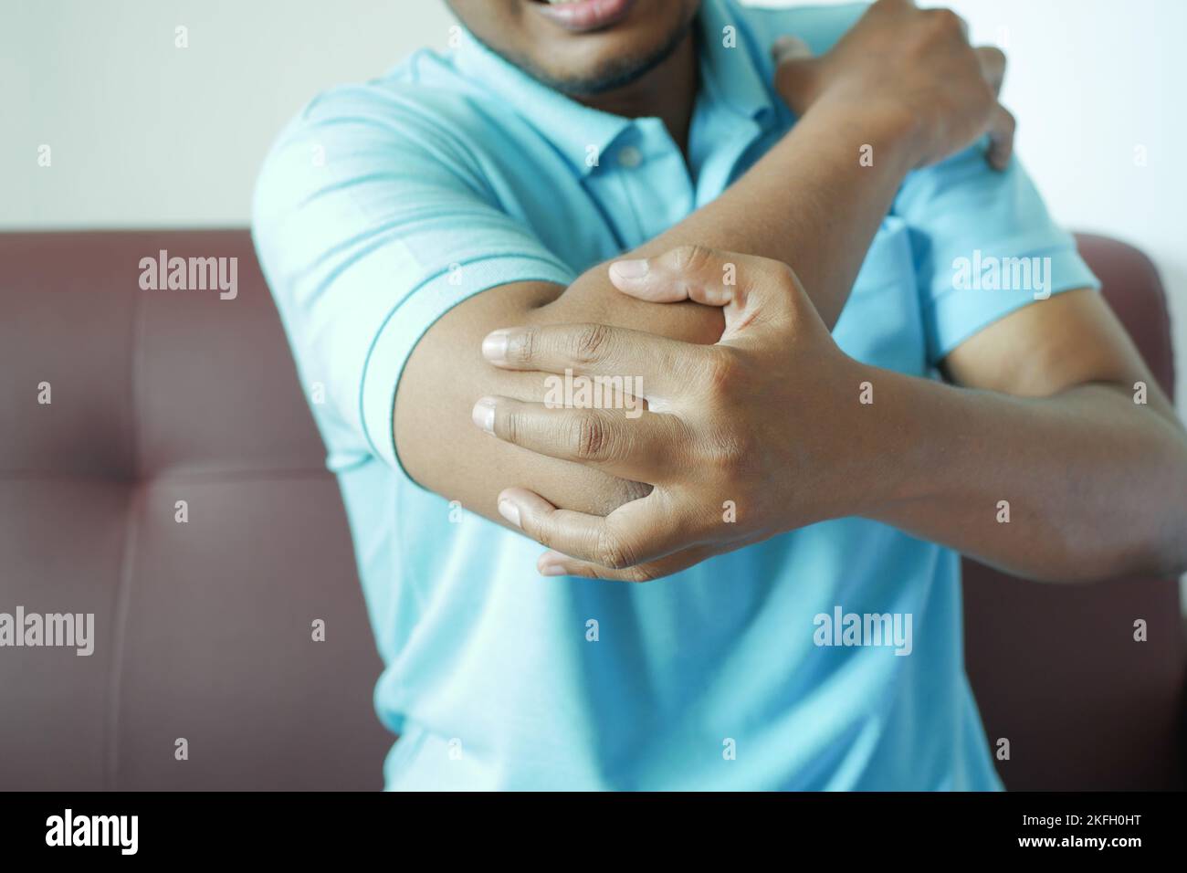 young man suffering pain on elbow Stock Photo - Alamy