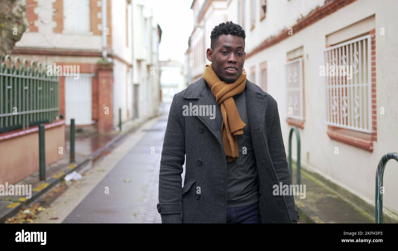 Happy black African man walking outside in European city smiling Stock ...