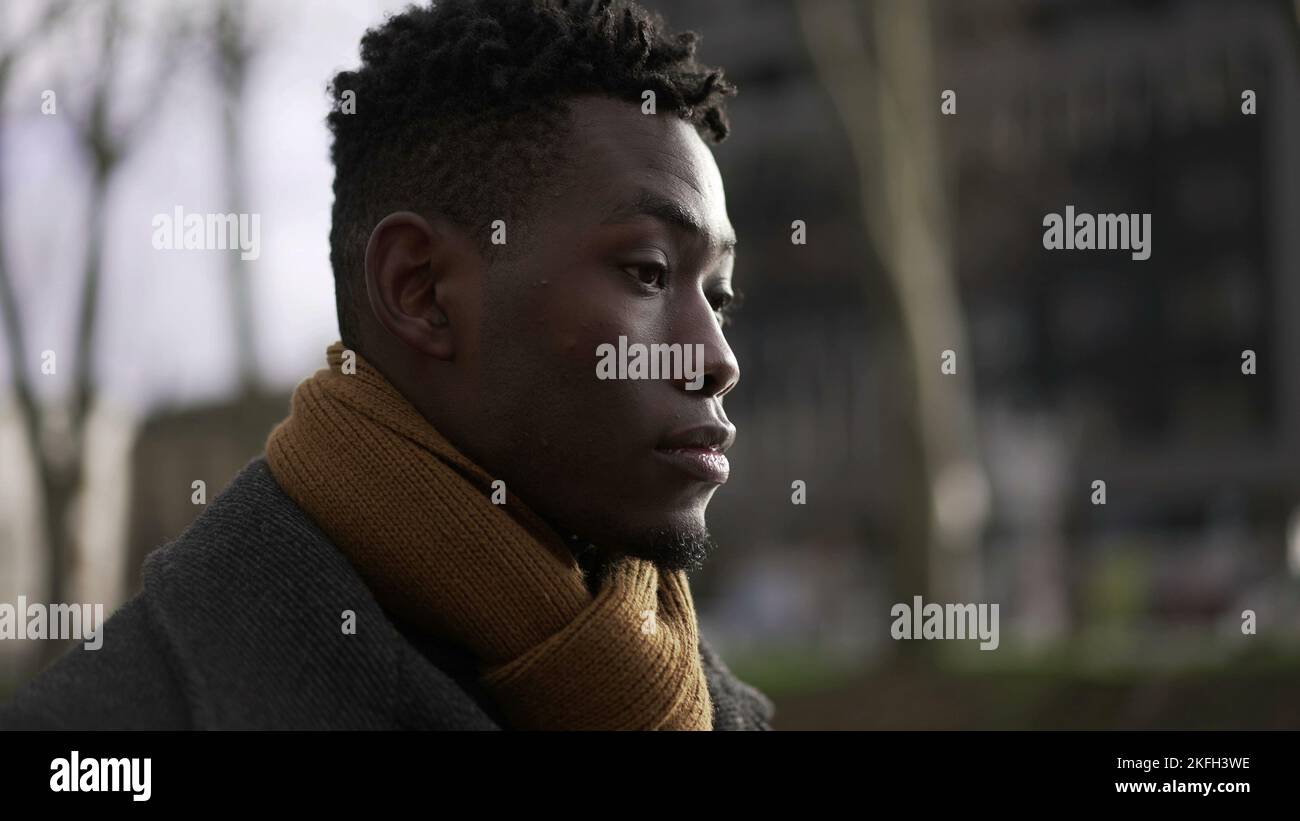 Elegant black man walking outside in nature park during winter season ...