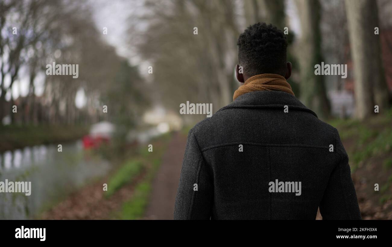 Elegant black man walking outside in nature park during winter season2 ...