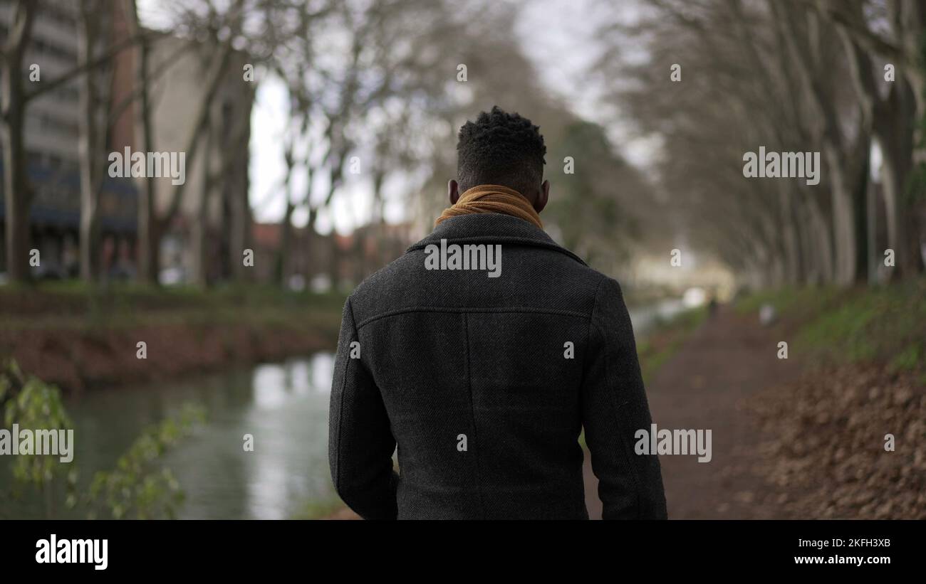 Elegant black man walking outside in nature park during winter season2 ...