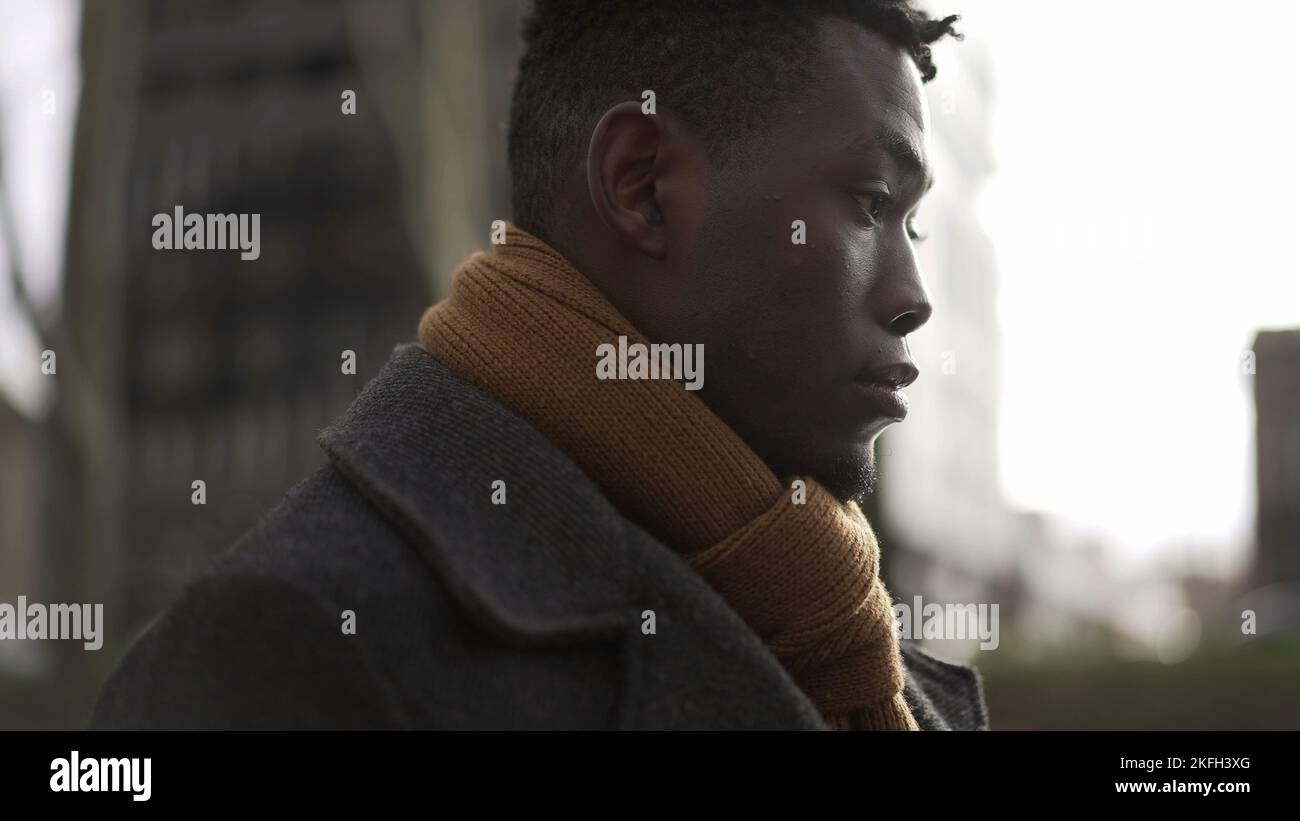 Elegant black man walking outside in nature park during winter season ...