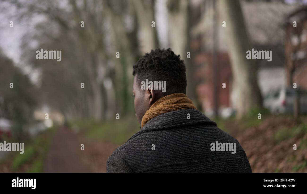 Elegant black man walking outside in nature park during winter season2 ...