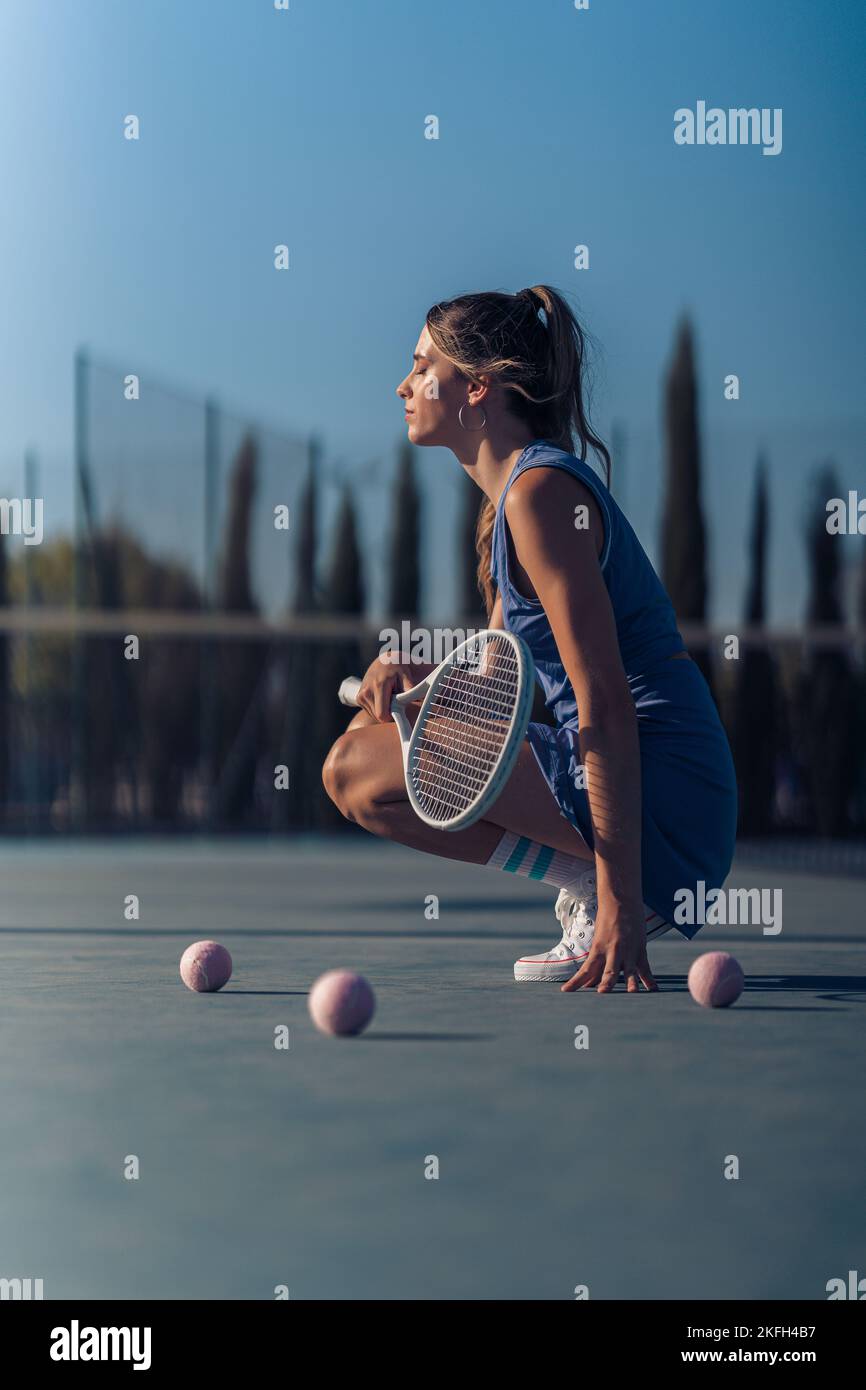 A vertical closeup of a tennis player popping on the tennis court ...