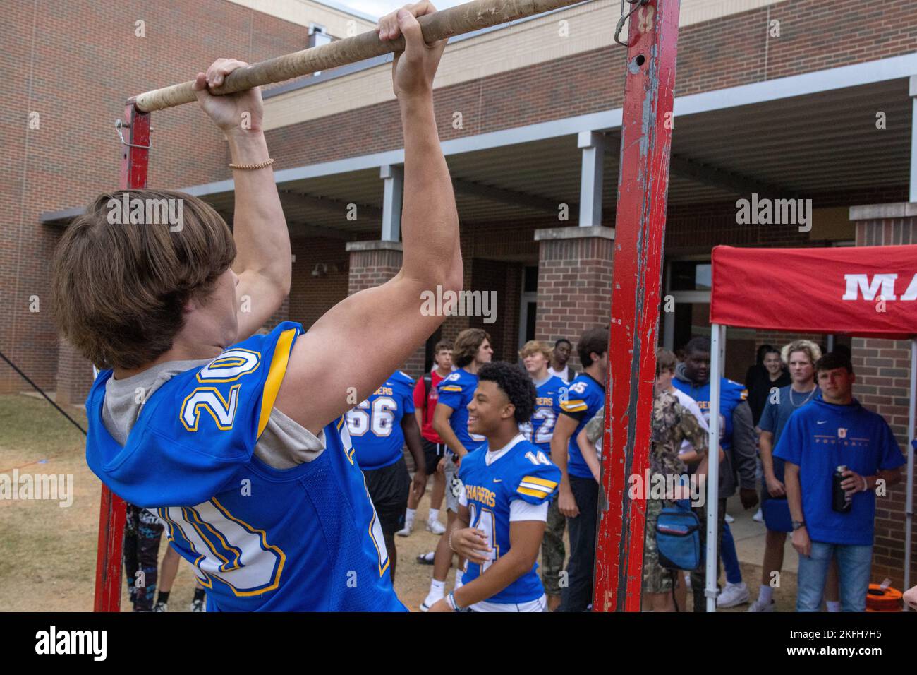 An Oxford High School football player performs pull-ups to contribute ...