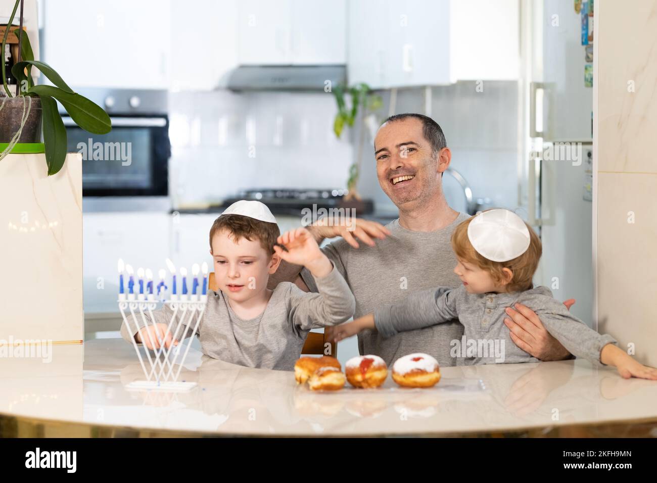 Father and sons with menorah celebrate hanukkah - Jewish religious ...