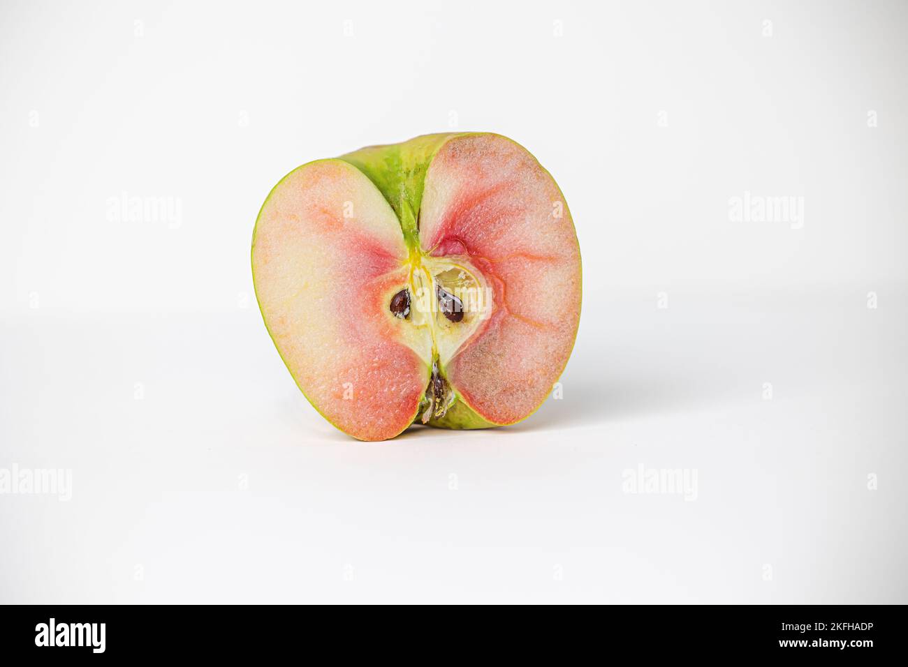 One half of a single lucy glo apple on a white background Stock Photo ...