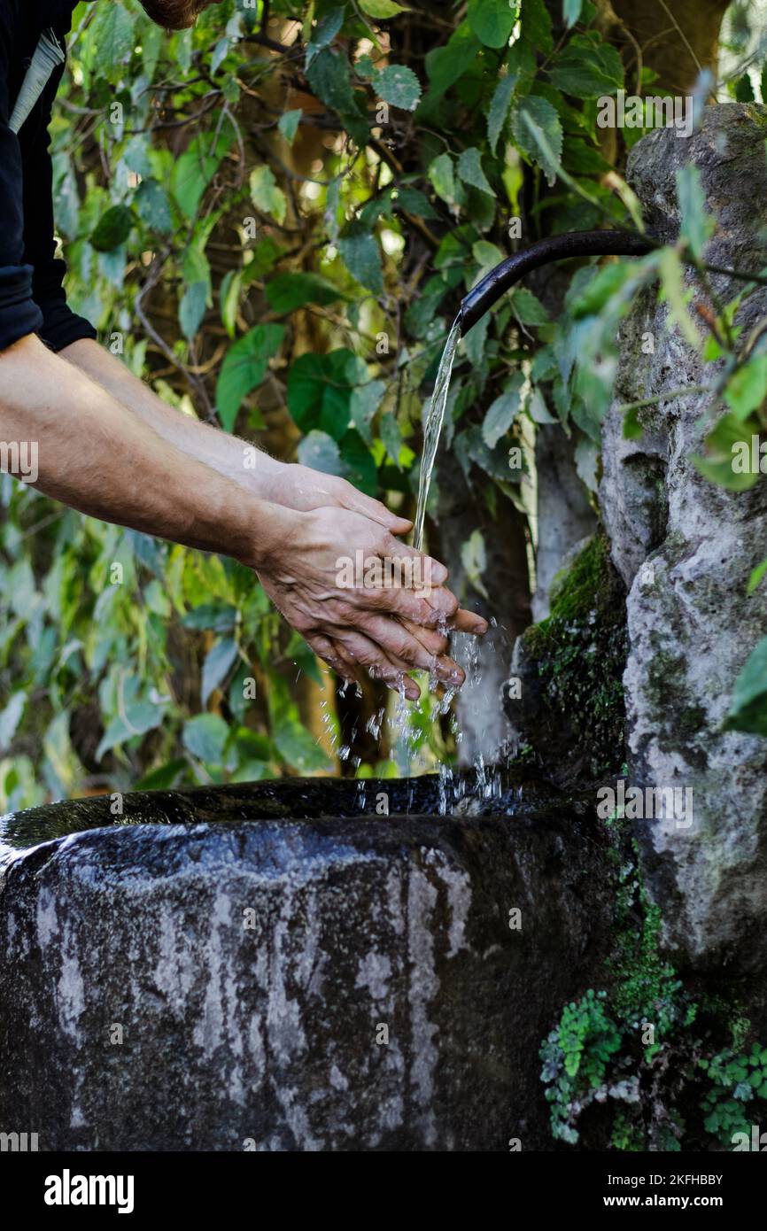 Antique drinking fountain in Italy, Rome. A man washes his hands Stock ...