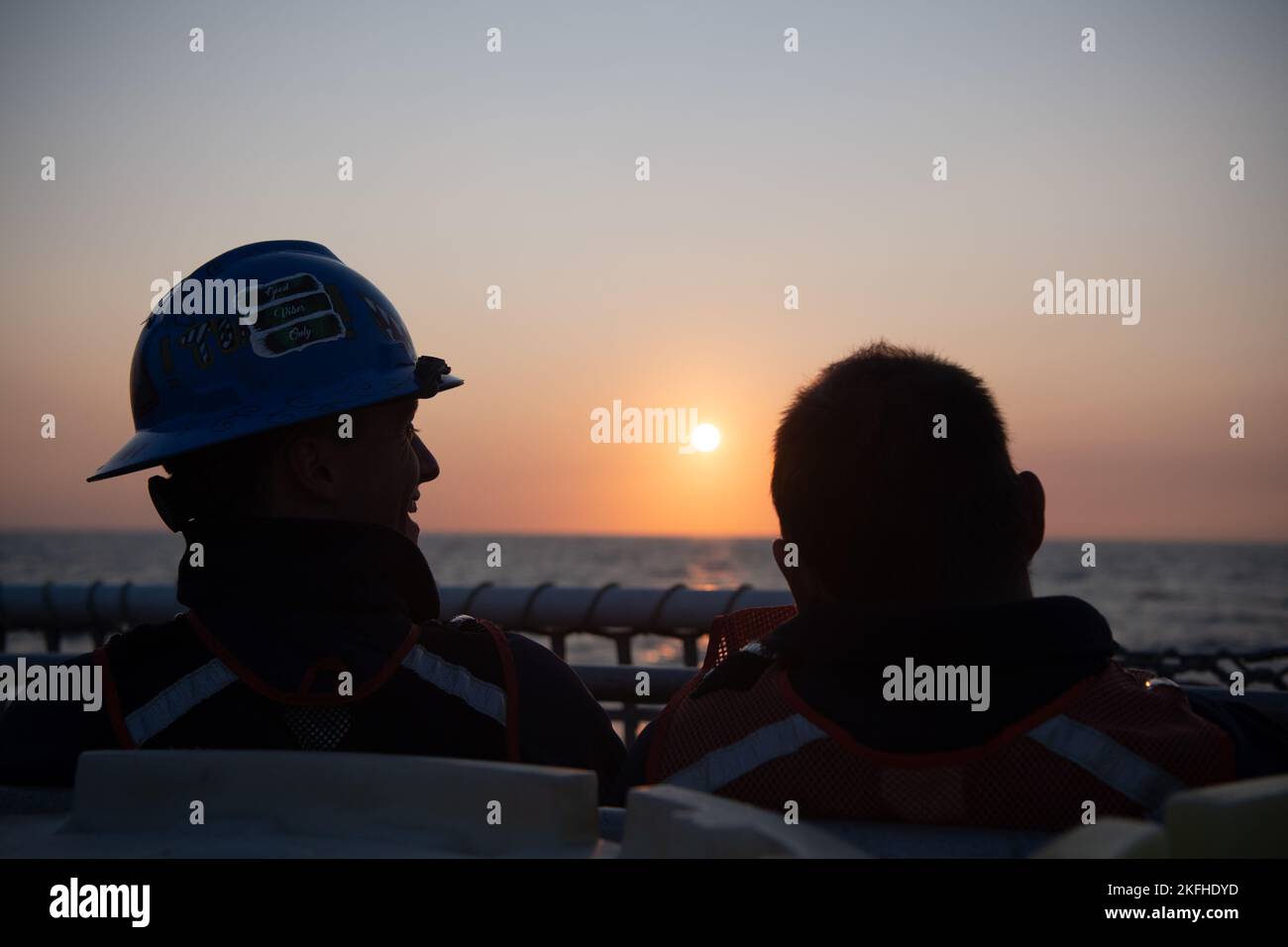Crew members aboard USCGC Bear (WMEC 901) watch the sunrise after ...