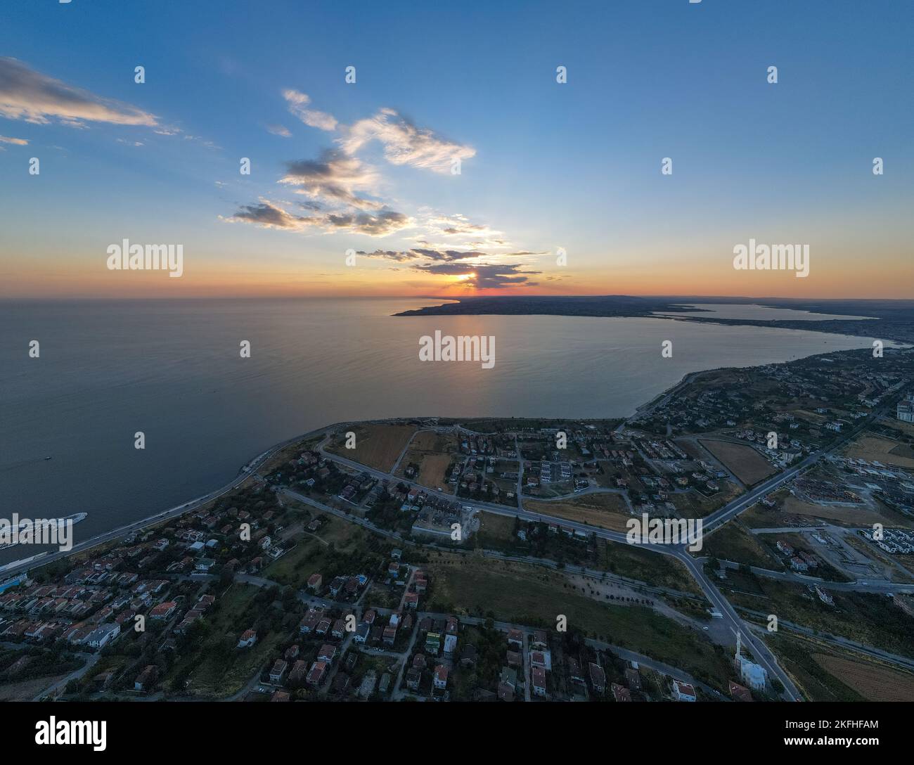 An aerial view of the sea and the coastal town in Istanbul at sunset ...