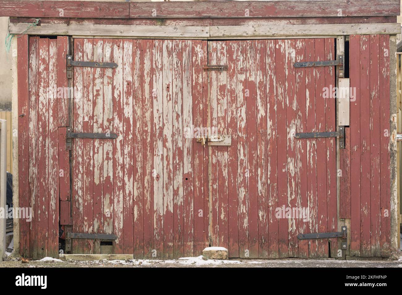 Old rustic red worn garage doors. Rotting wood with metal hinges Stock ...