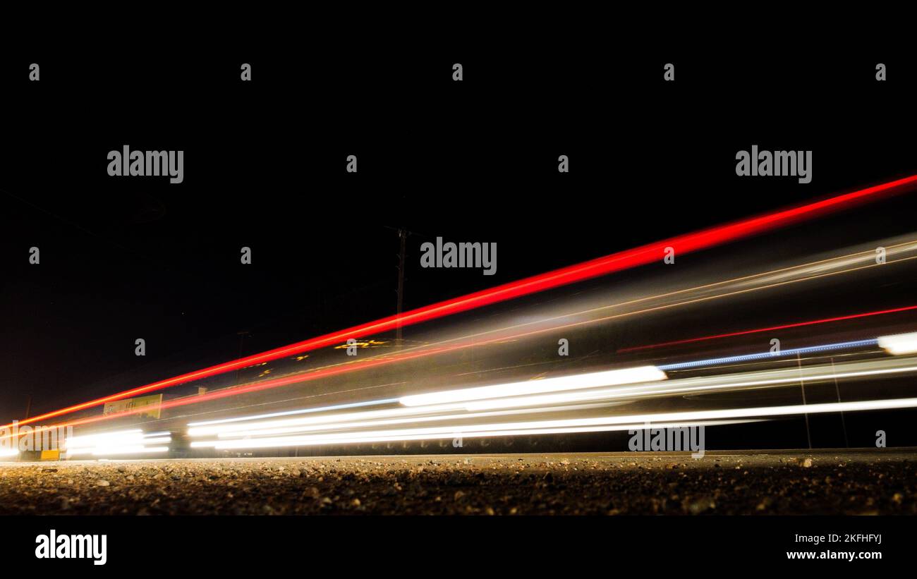 A long exposure shot of car headlights on a dark road Stock Photo - Alamy