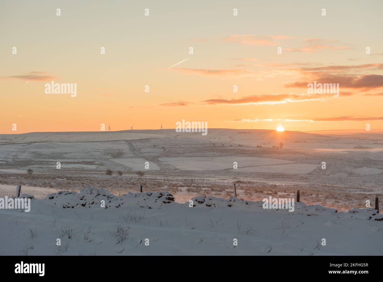 Sun rising over the Rossendale wintry moorland. Bleak moors covered in ...