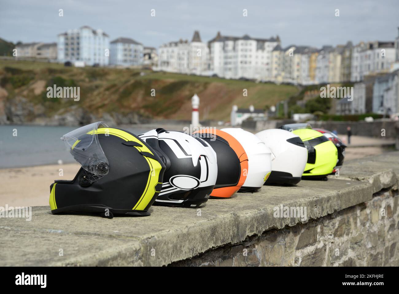 Motorcycle helmets in a row on the sea wall Stock Photo - Alamy