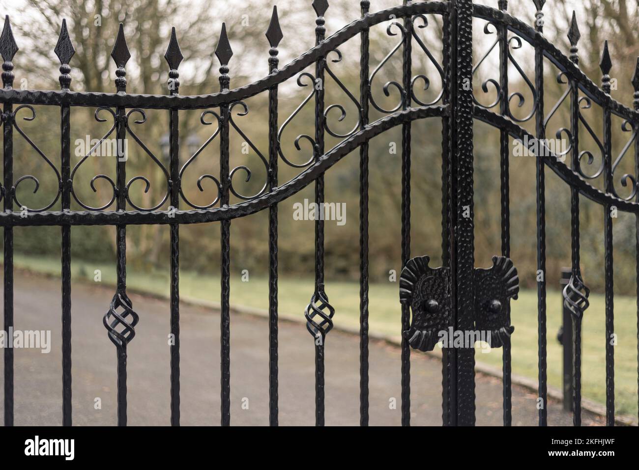 wrought iron gate painted black. Ornate lock mechanism Stock Photo - Alamy