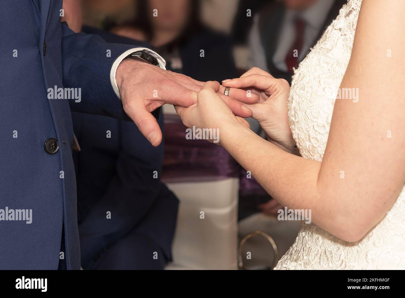 Bride placing wedding ring on grooms finger during the wedding ceremony Stock Photo - Alamy