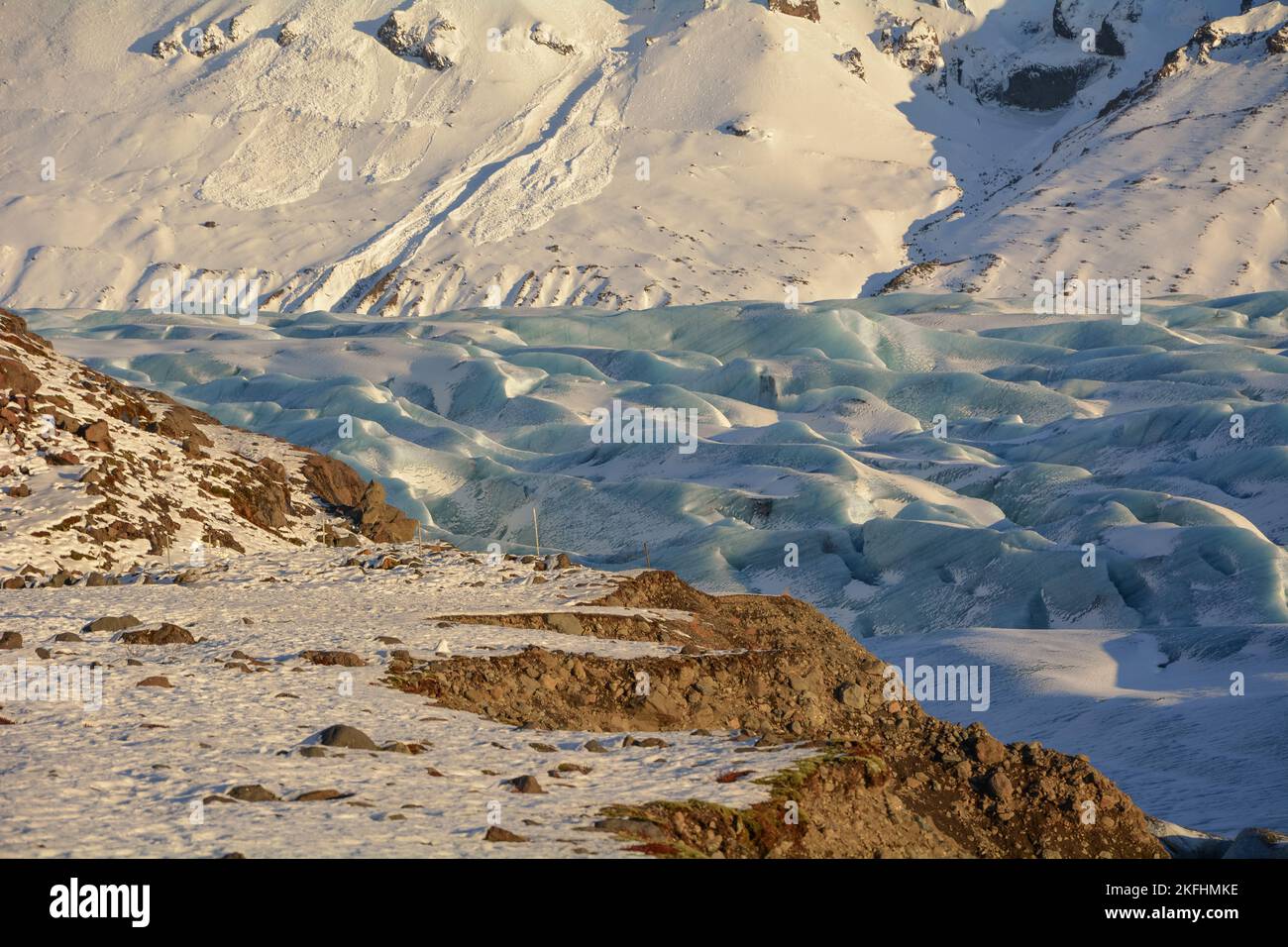 Icelandic glacial field with rugged snow covered mountains raising up ...