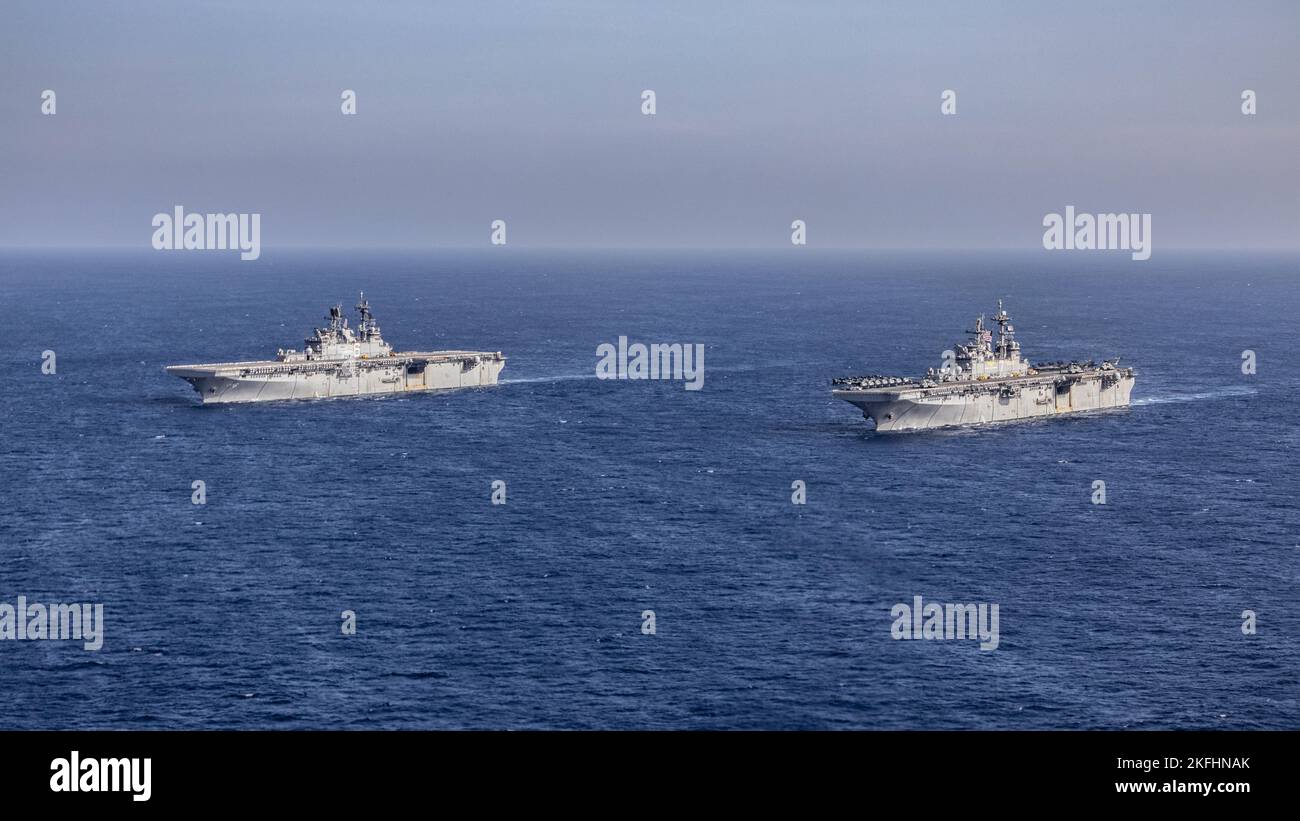 Amphibious assault carrier USS America (LHA 6), left, sails in front of ...