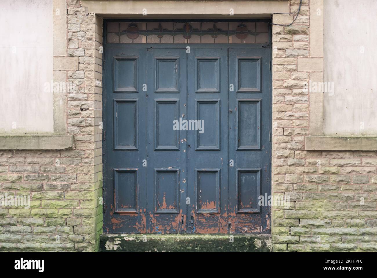 Old wooden door with square paneling. old bricked up windows. Blue door ...