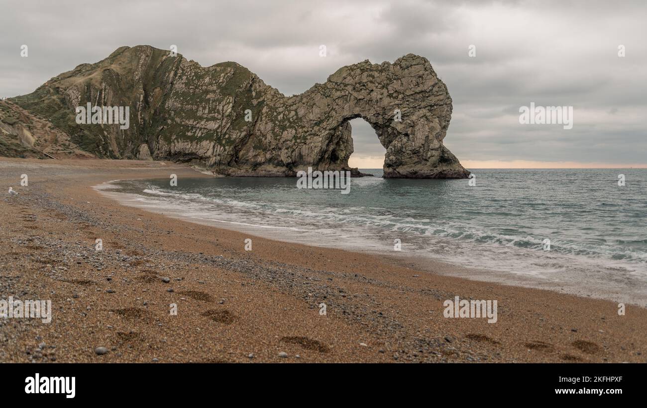 Durdle Door, south coast of England. Large stone structure with door ...