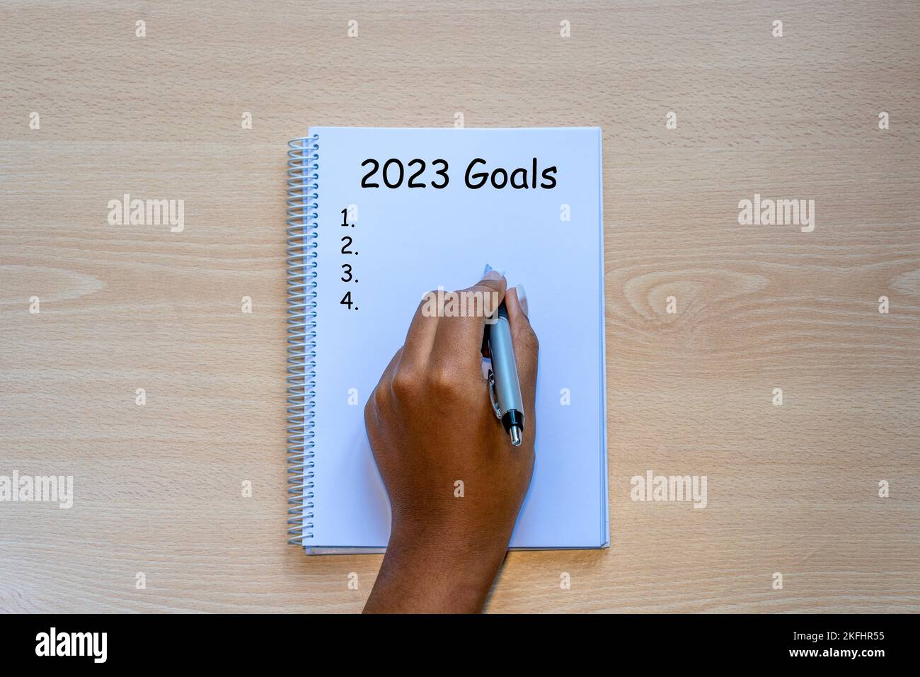 African American woman's hand writing in a notebook the 2023 Goals on ...