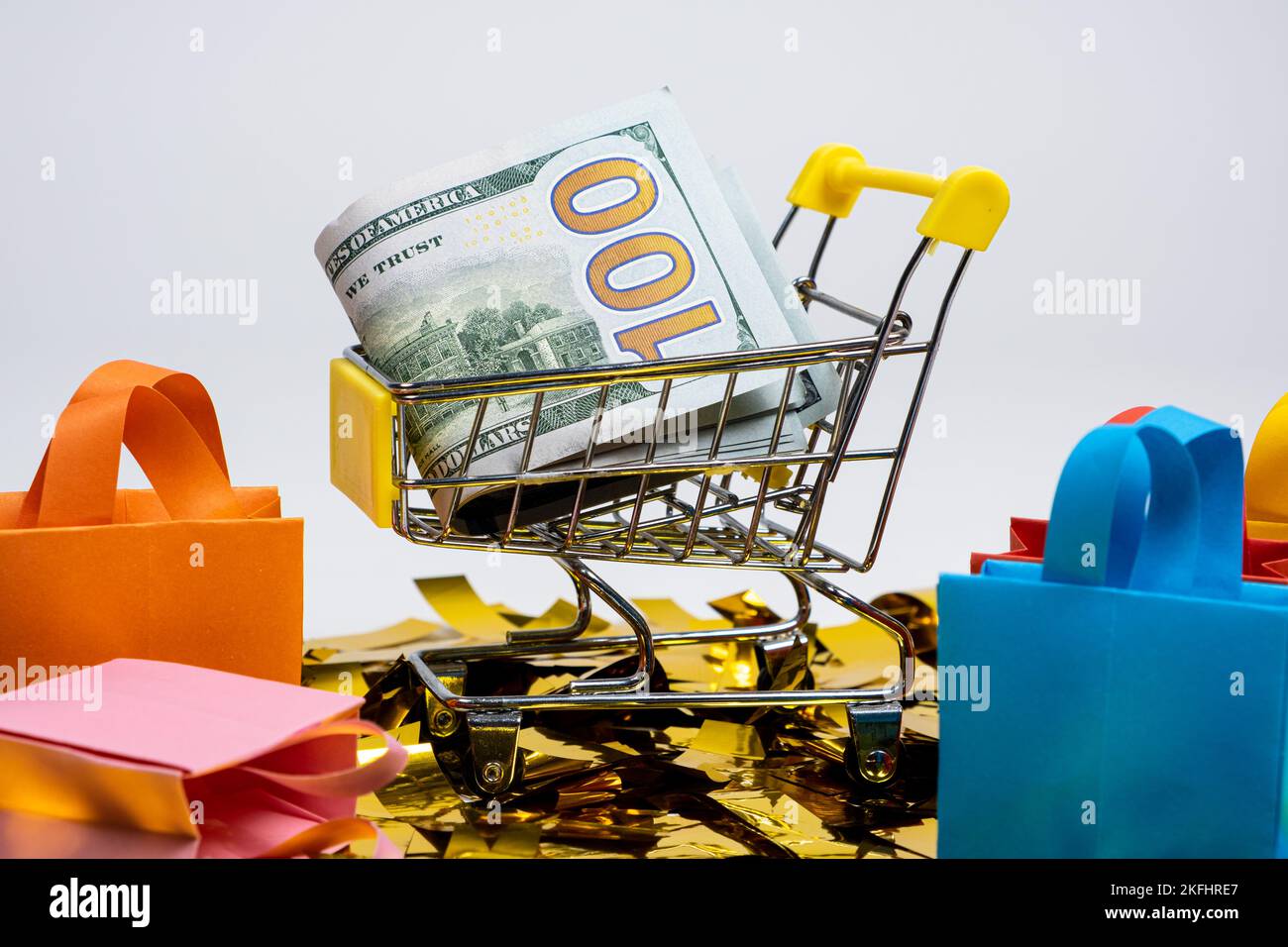 Shopping bags and a cart with money on a white background. The concept ...