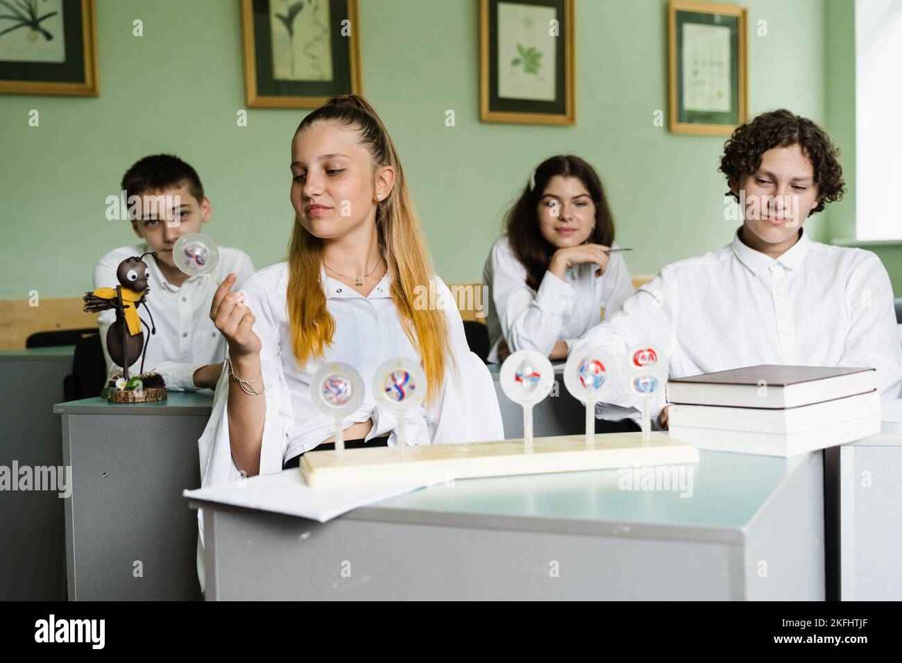 Pupils at biology lesson at school with animal cell models on the table ...