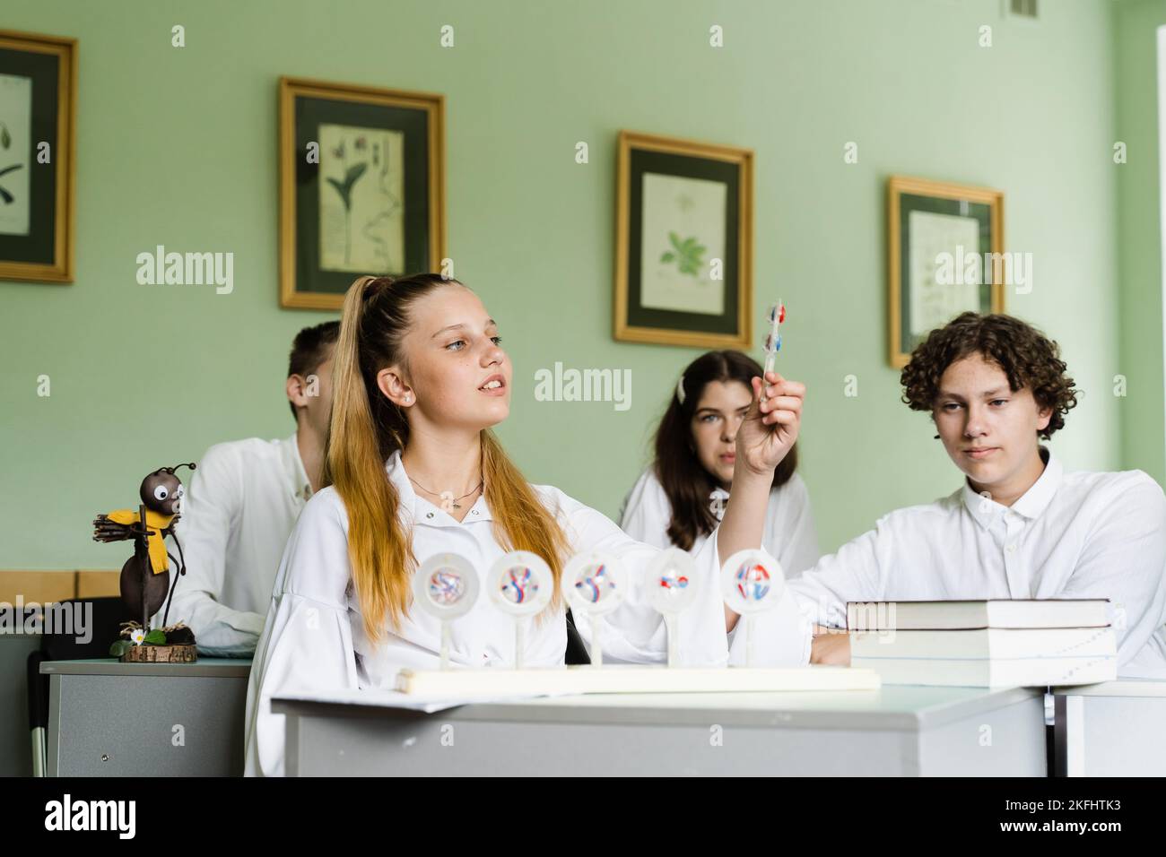 Pupils at biology lesson at school with animal cell models on the table ...