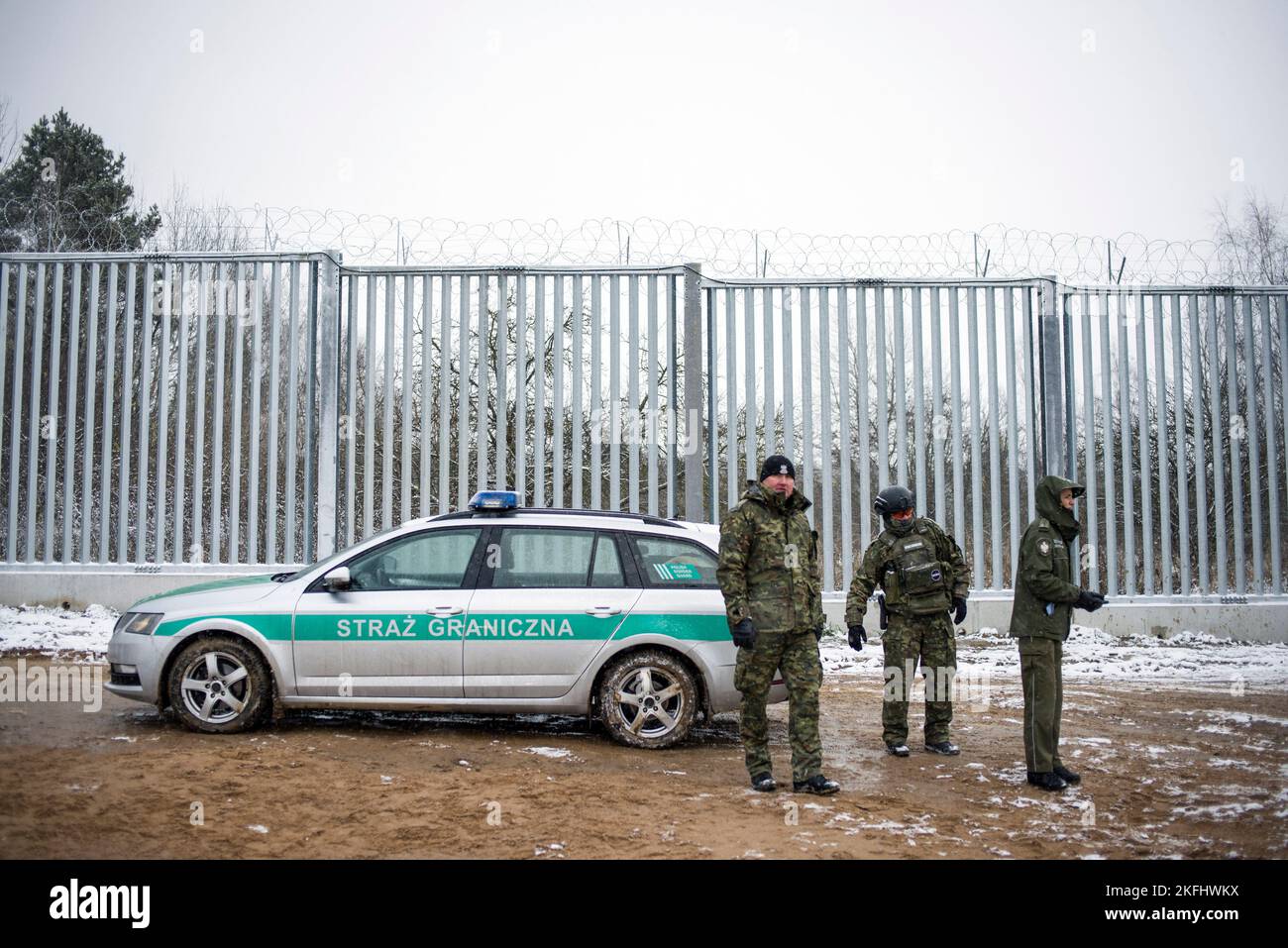 Polish border guards are seen guarding the border wall dividing Poland ...
