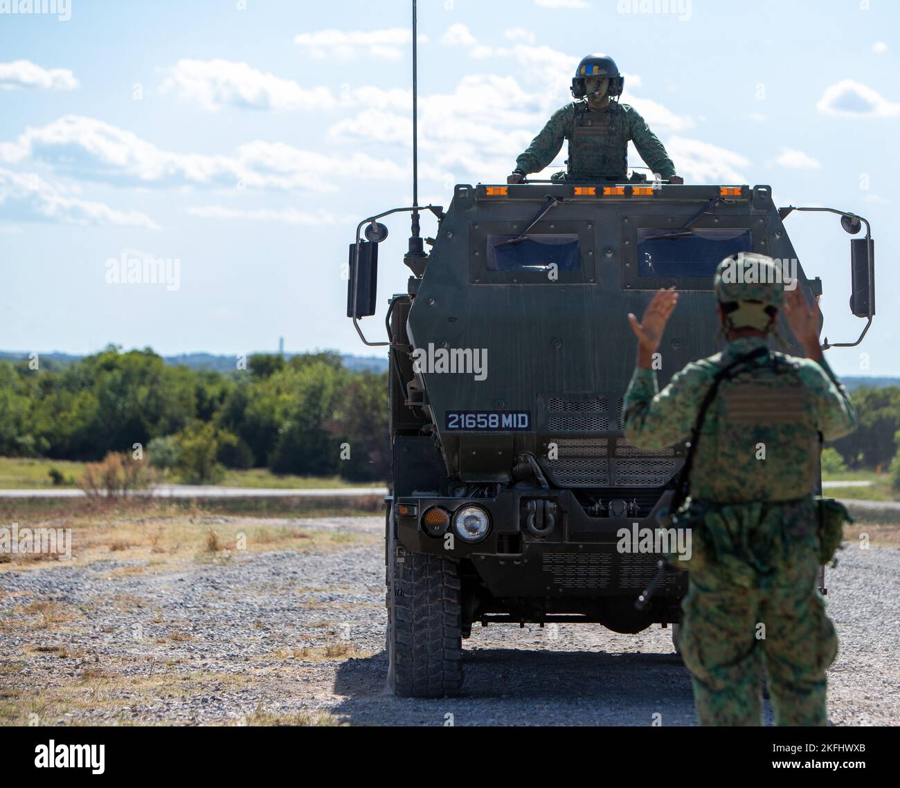 A noncommissioned officer with the 23rd Singapore Artillery guides a ...
