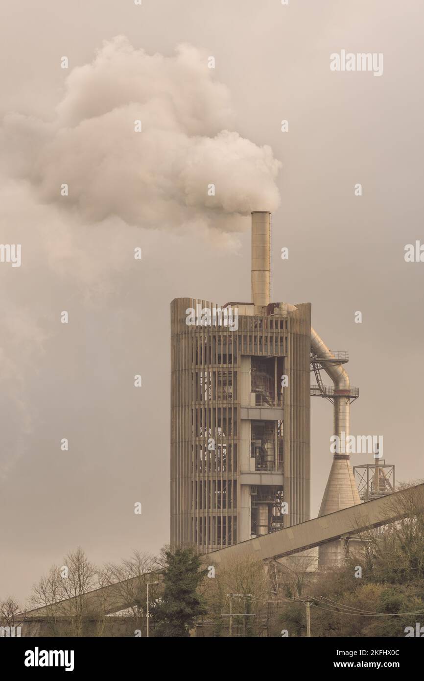 Tall industrial steel machinery with steam pumping out of the chimney ...