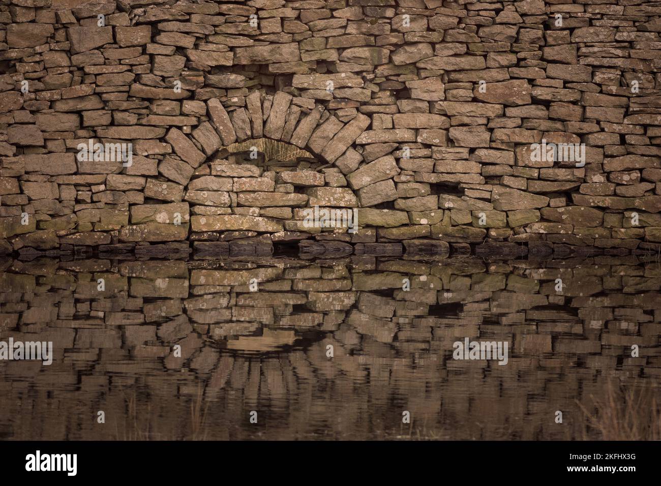 Stone wall with arched pattern. Reflection in the water. Pretty pattern ...