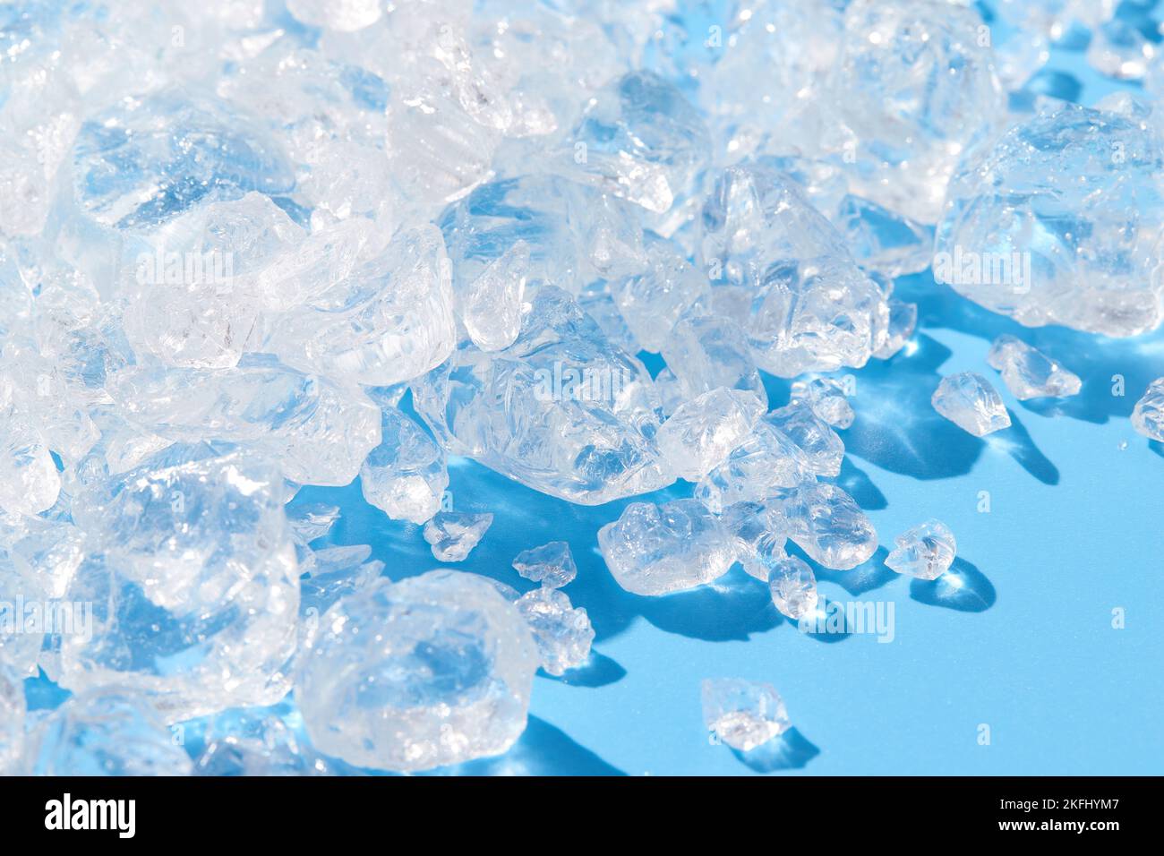 Close up crushed ice in sunlight on blue. Summer background refreshment ...
