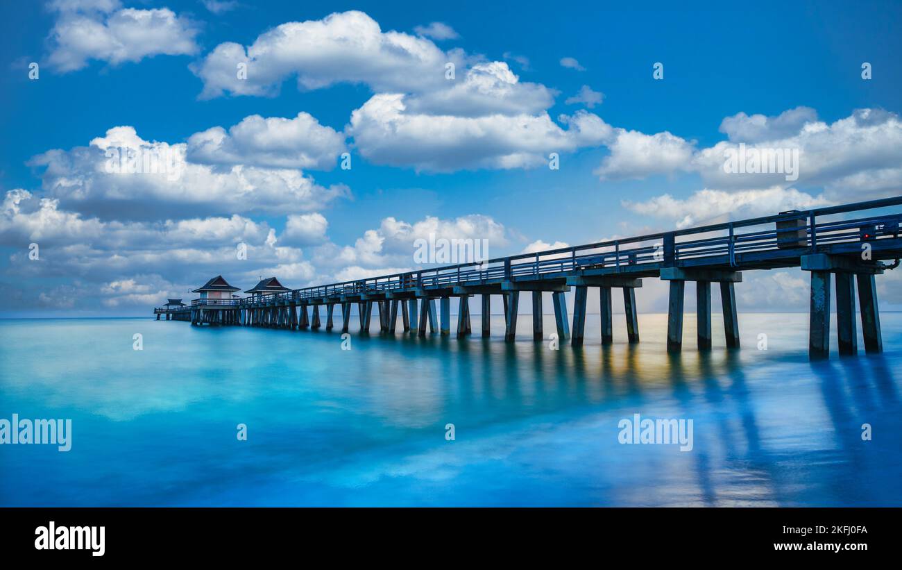 The beautiful Old Naples Pier over water in Florida under a bright cliudy sky Stock Photo - Alamy