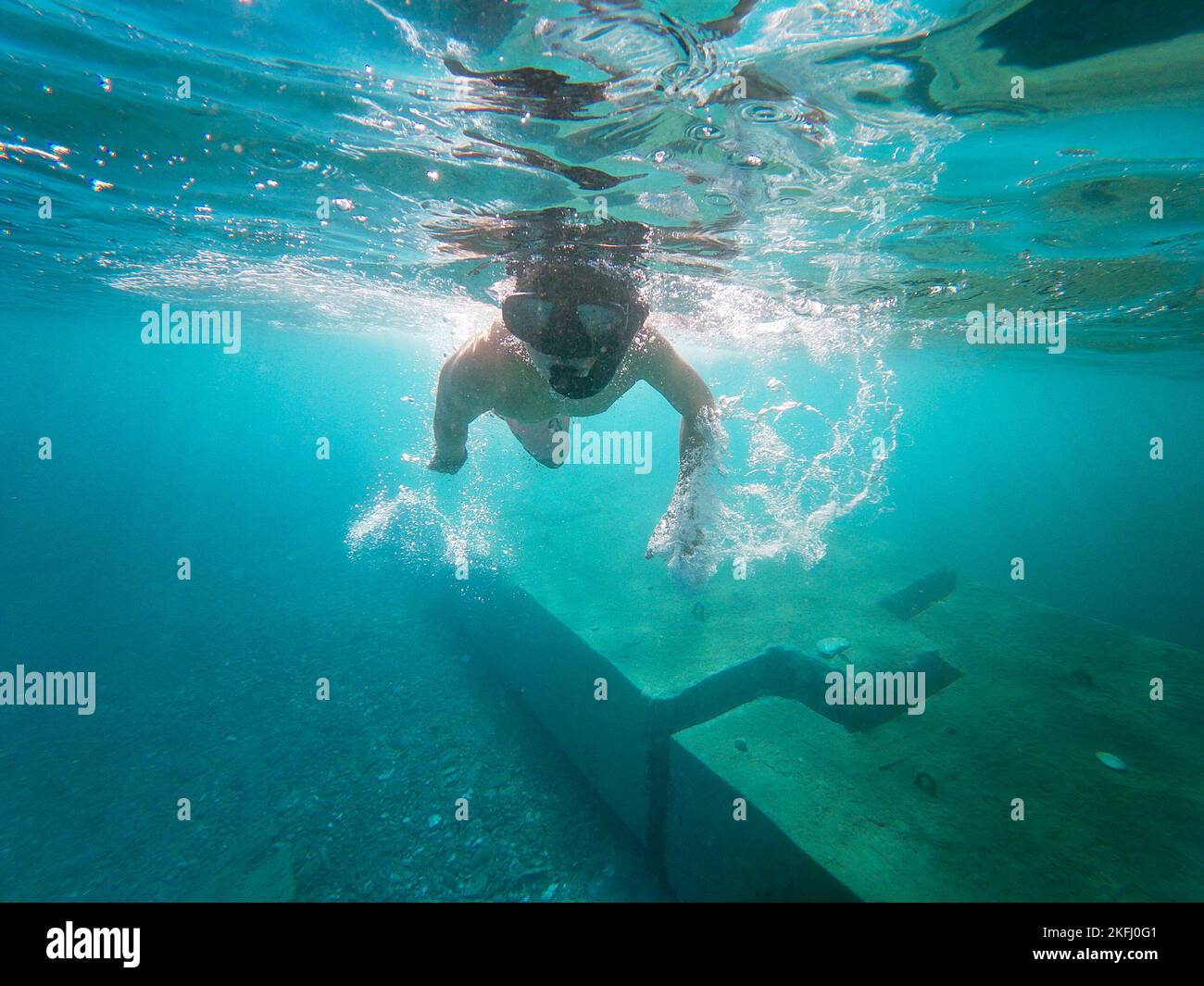 Carefree caucasian man wearing snorkel diving under water in sea while ...