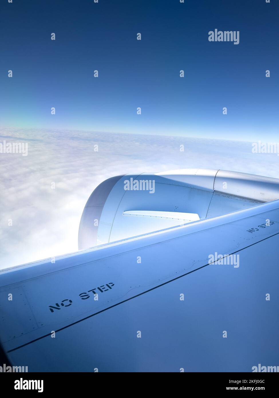 Cropped image of airplane's jet engine flying over scenic cloudscape ...