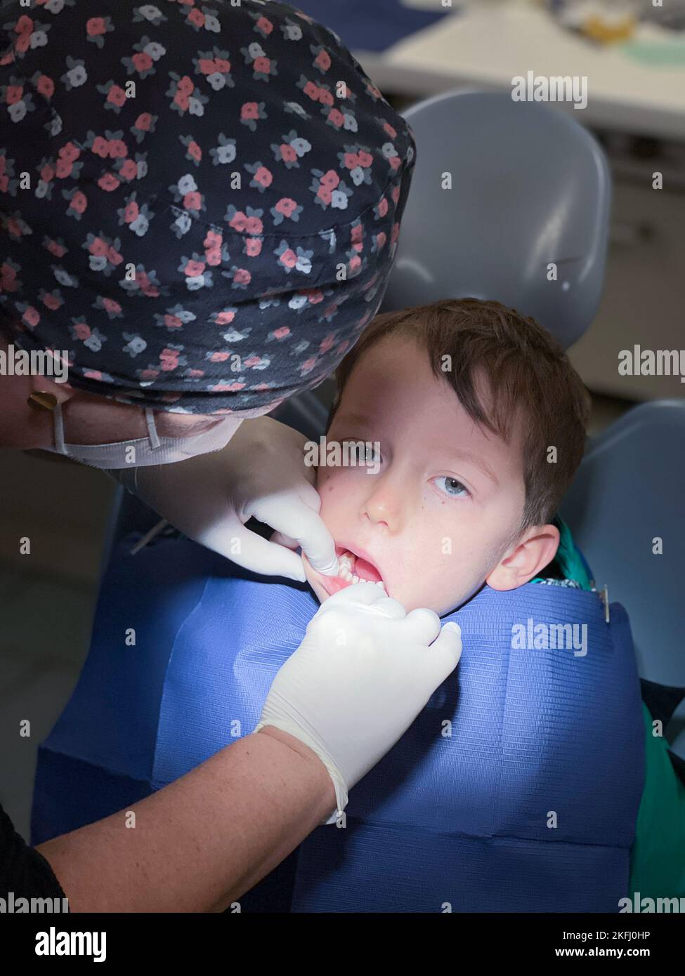 High angle view of female dentist wearing floral cap and surgical ...