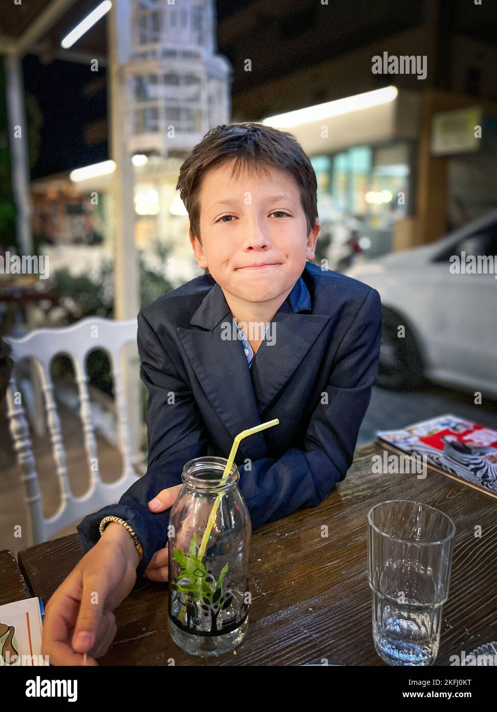 Portrait of cute caucasian boy wearing blazer having refreshment drink ...