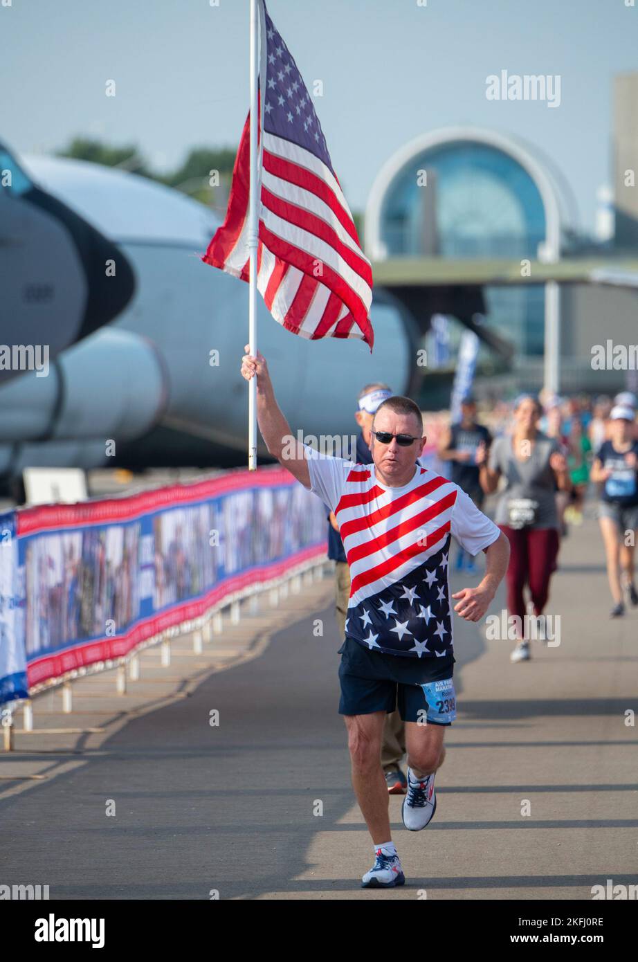 Robert Armstrong carries an American flag as he approaches the finish ...
