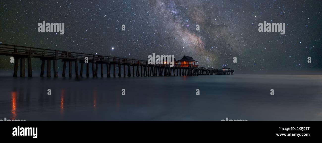 The beautiful Old Naples Pier over water in Florida under a starry ...