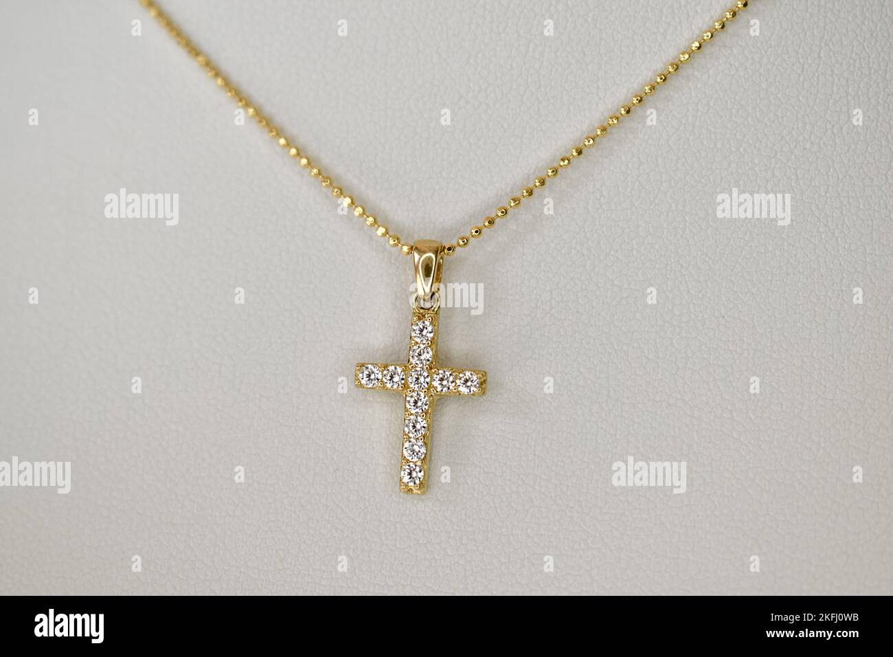 A golden cross necklace isolated on white background Stock Photo - Alamy