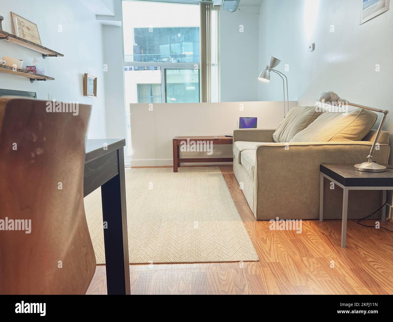 illuminated lamps arranged on side tables by sofa in modern living room ...