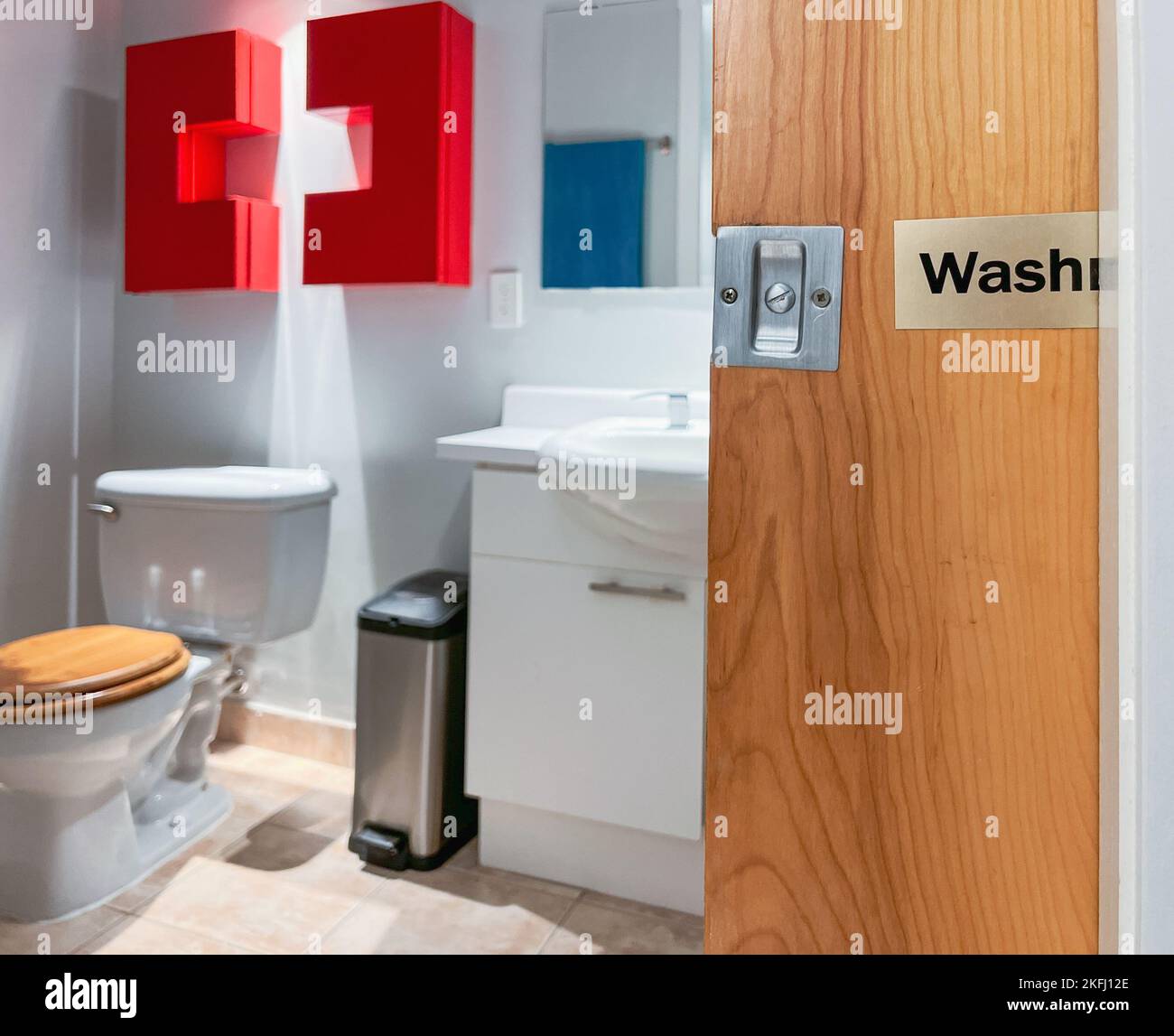 Washroom text on wooden sliding door and modern toilet seen through ...