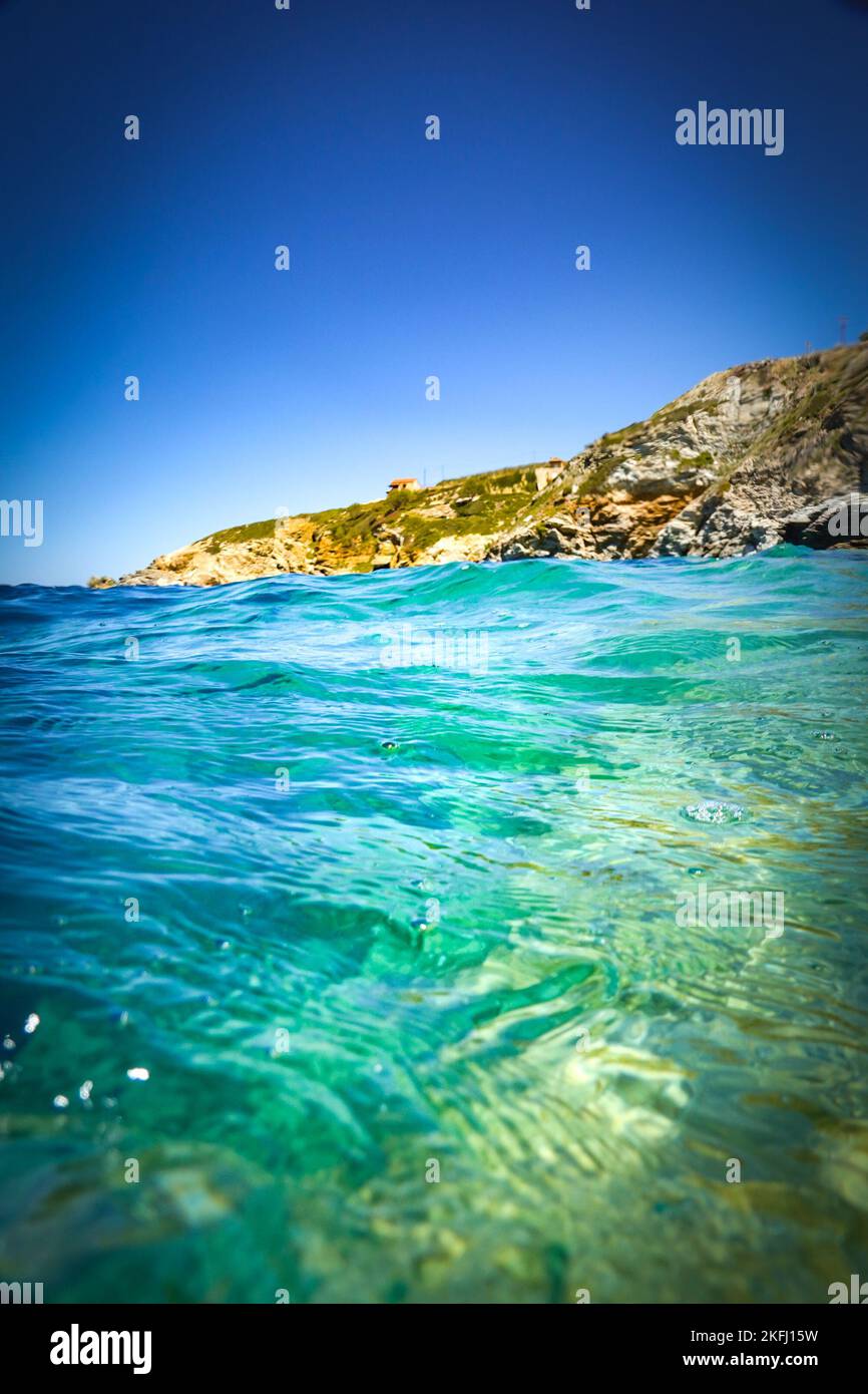 Surface level of waves in seascape by rocky mountain clear blue sky ...