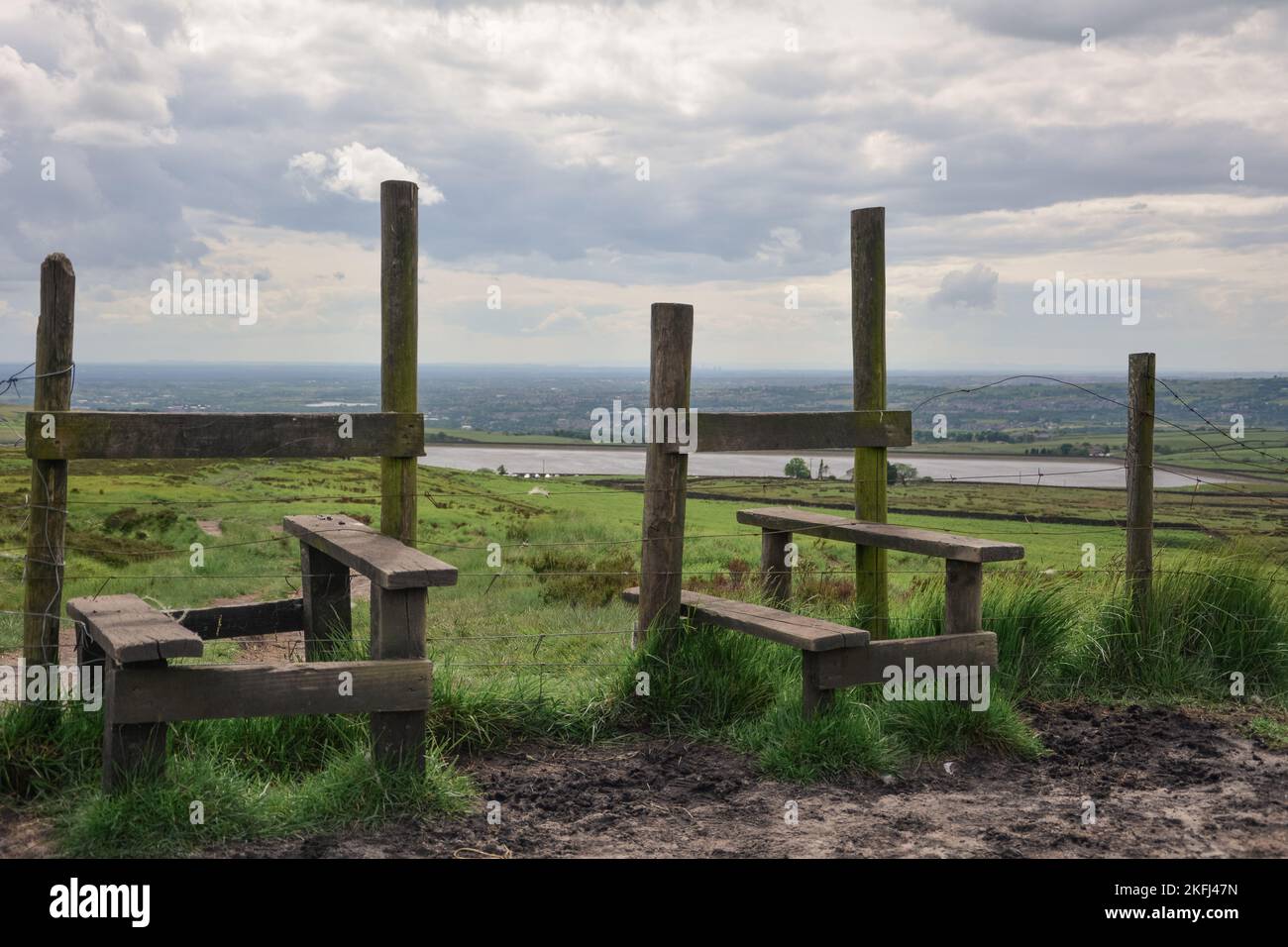 Two styles on the footpath with Manchester in the background. Cloudy ...