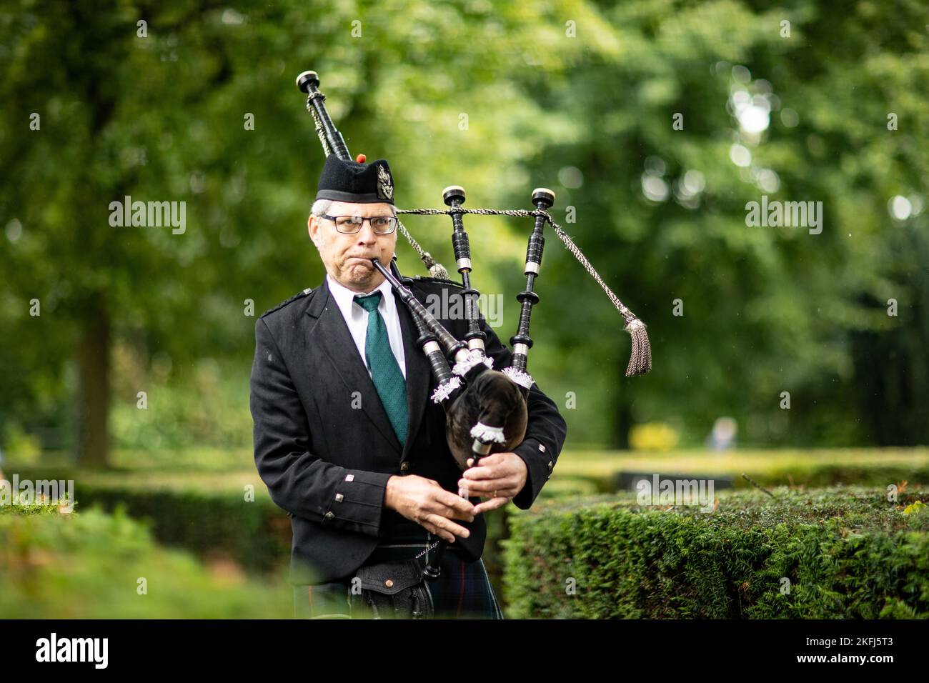 A bagpipe player plays the bagpipe to honor World War II veterans ...